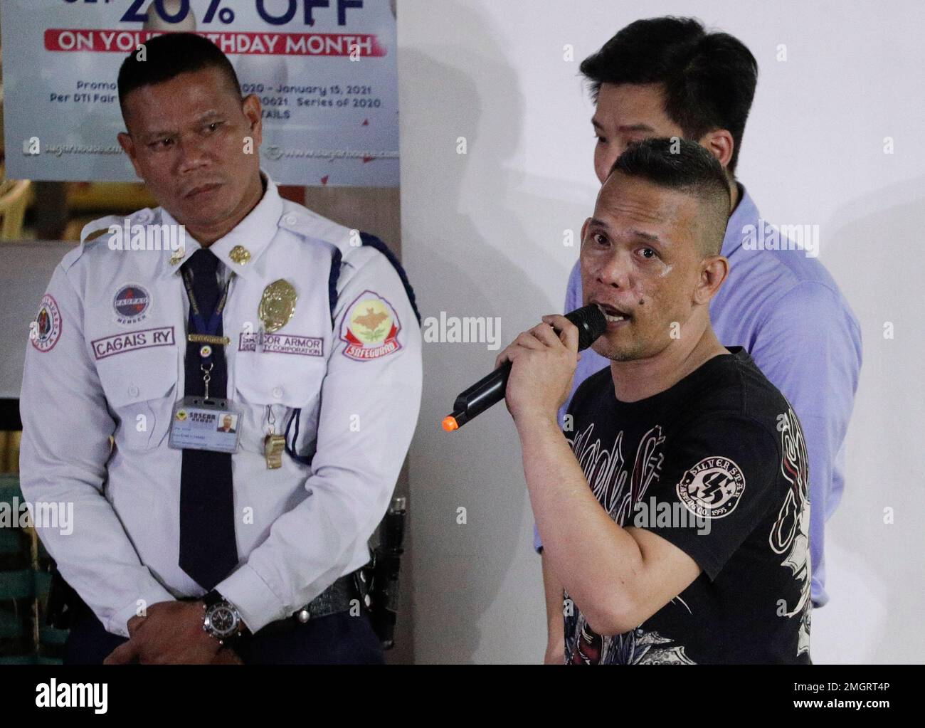 Former security guard Alchie Paray, right, talks to media shortly after releasing all his ...
