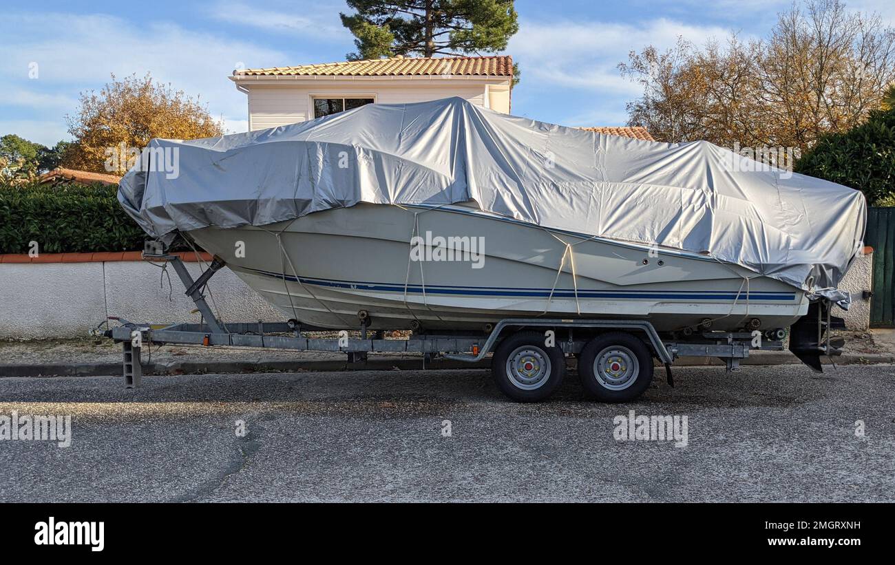 boat under tarpaulin tarp on car trailer Stock Photo - Alamy