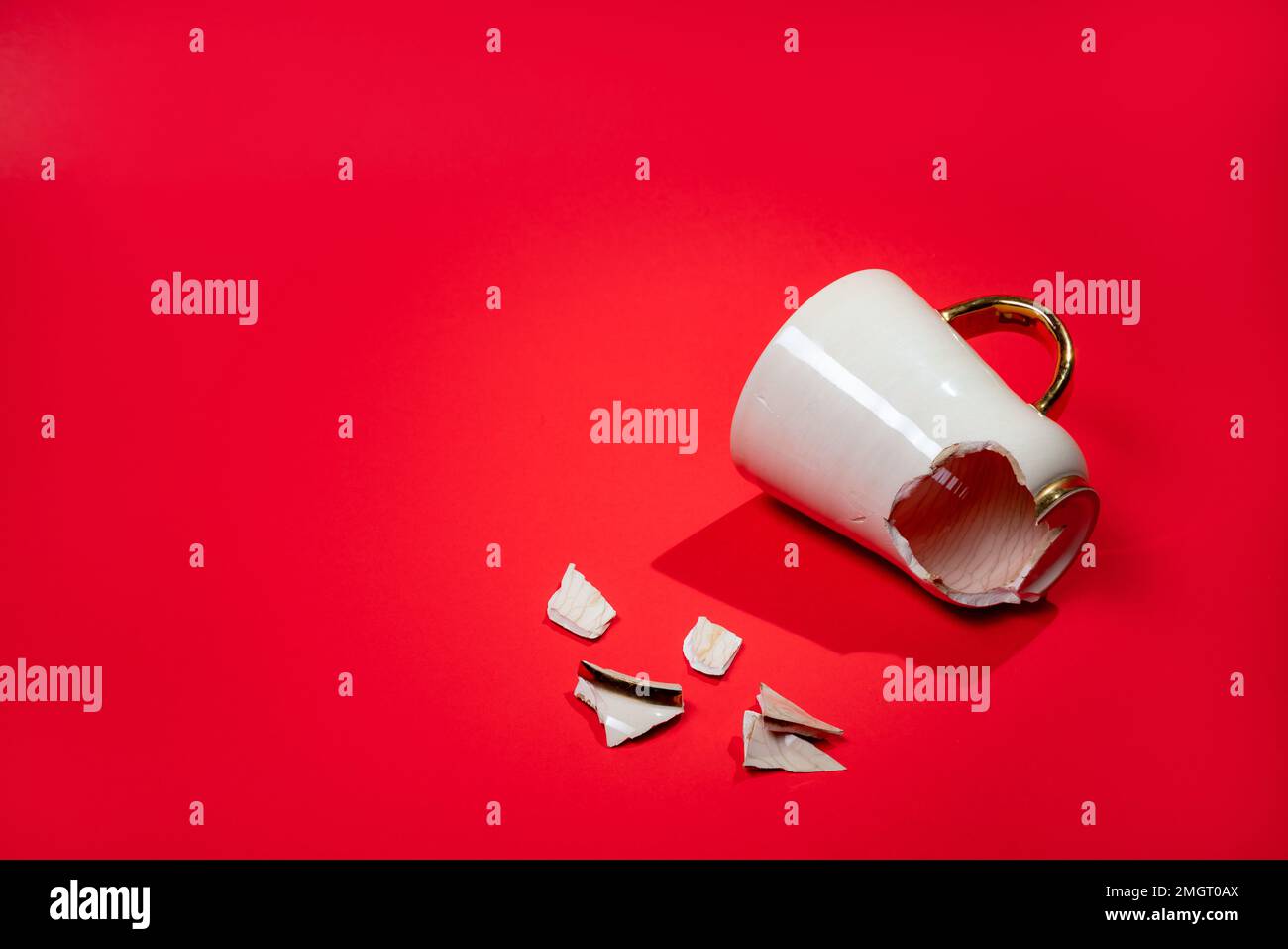 Broken tea cup isolated on red background. Cracked coffee mug and ...