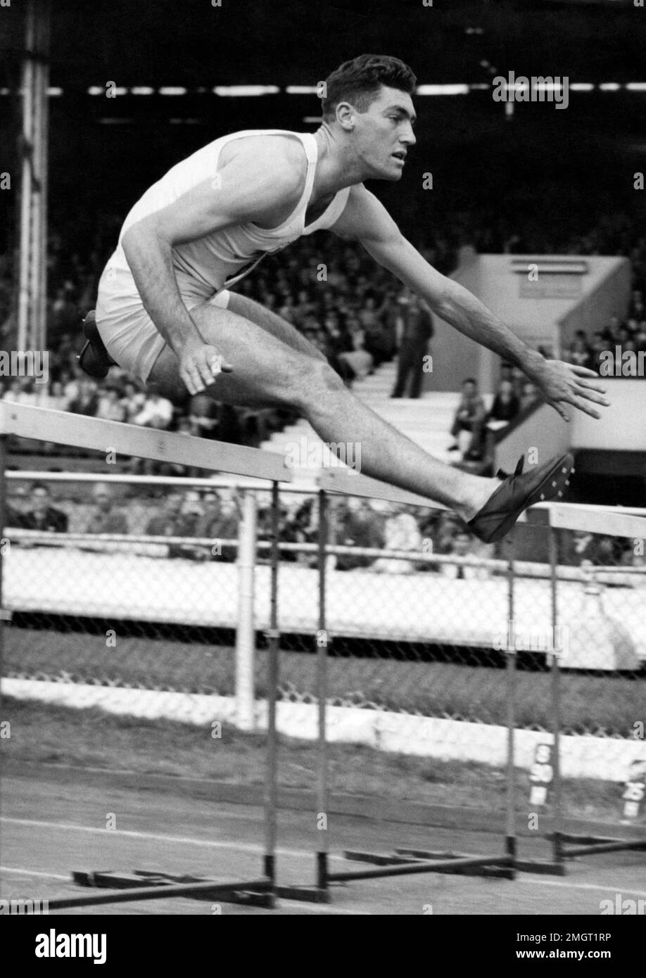 Peter M Mullins, a member of Australia's Olympic team, seen hurdling in ...