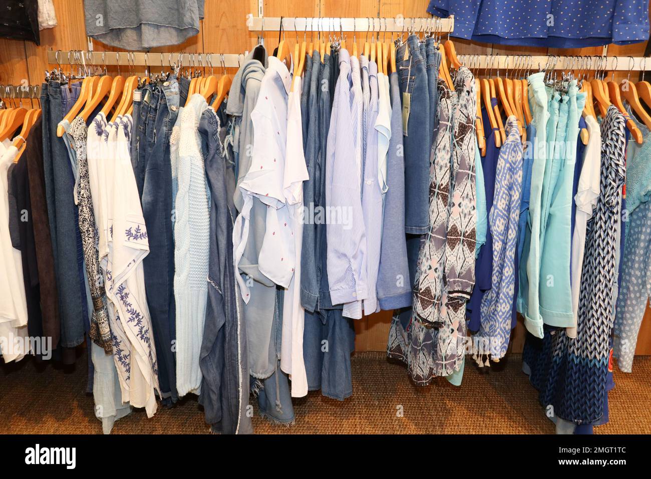 Cloth on clothes rail in clothing store Colorful women dresses on ...