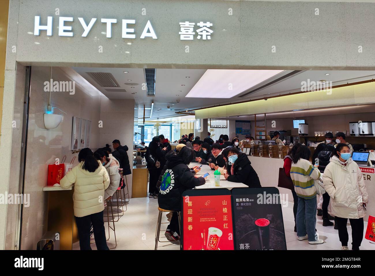 SHANGHAI, CHINA - JANUARY 26, 2023 - Young people drink milk tea while chatting on their mobile ...