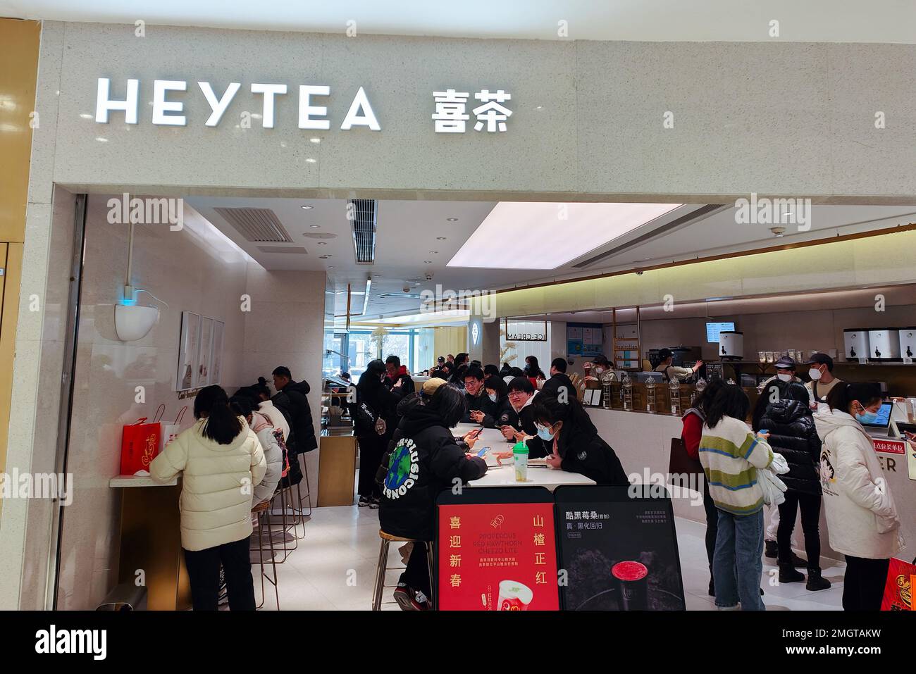 SHANGHAI, CHINA - JANUARY 26, 2023 - Young people drink milk tea while chatting on their mobile ...