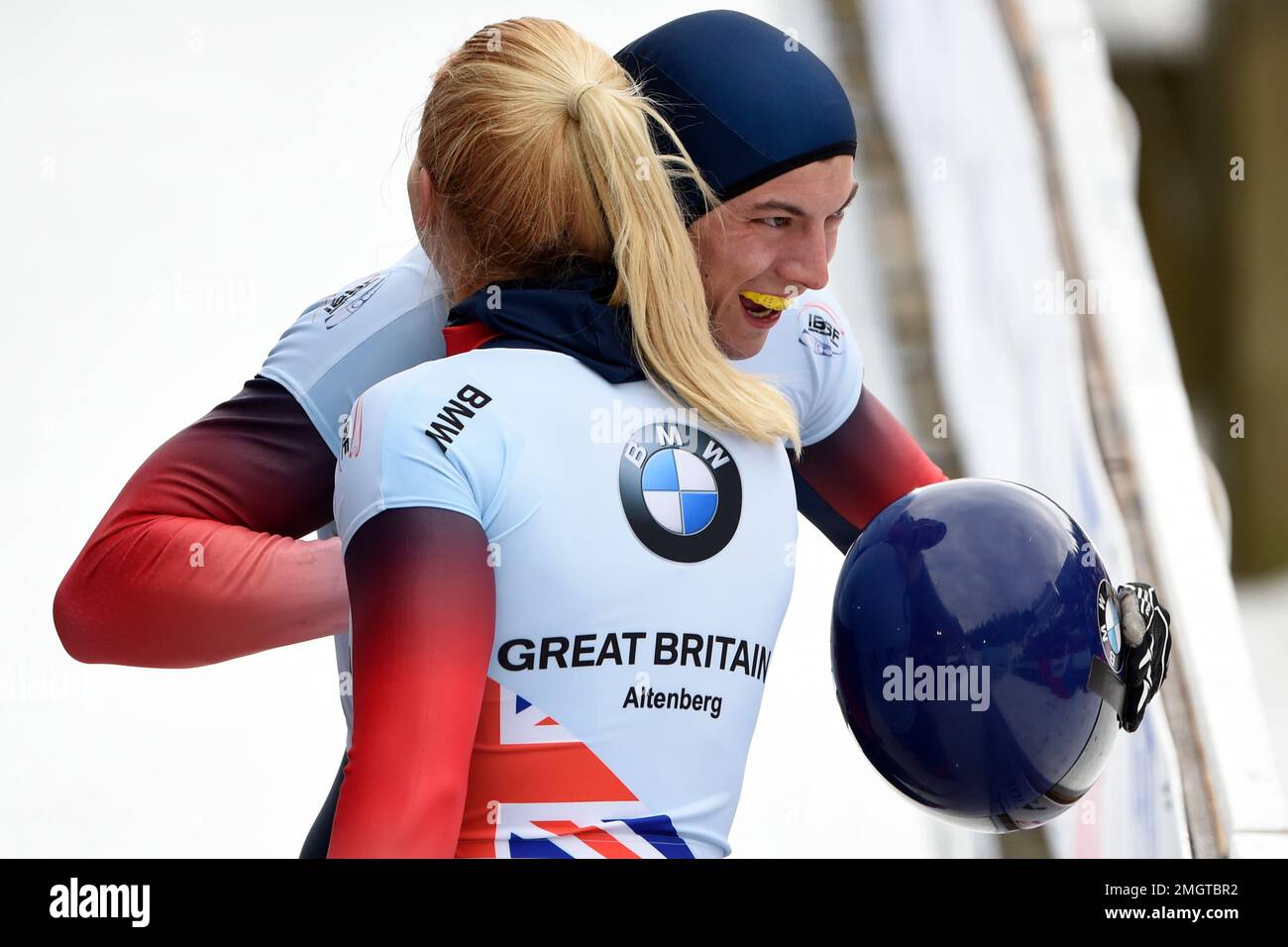 Matt Weston, background, hugs Madelaine Smith of Britain during the ...