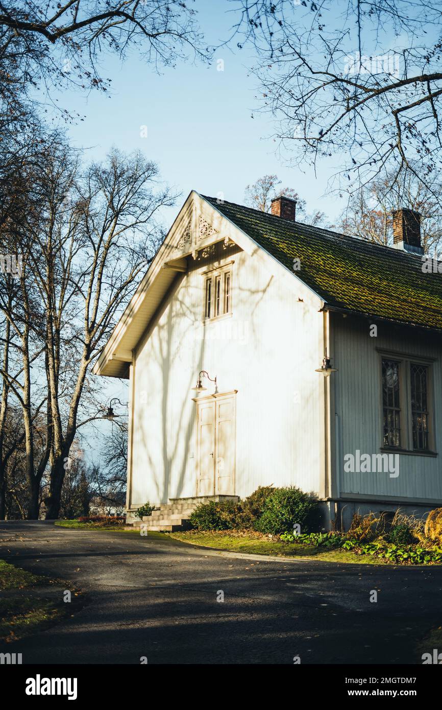 A vertical shot of an old white house in the countryside with green ...