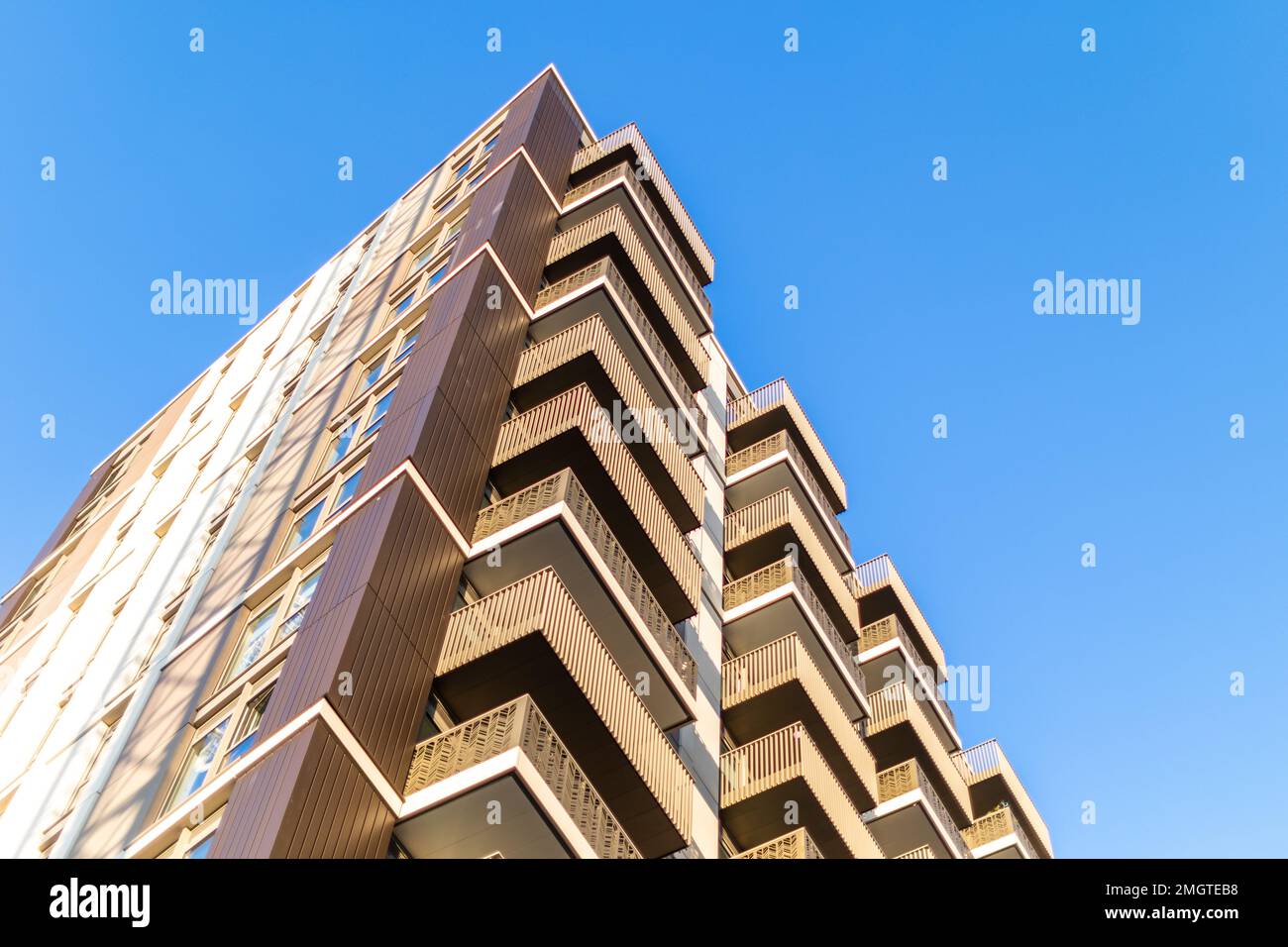 A low-angle view of a modern building with multiple balconies on the ...