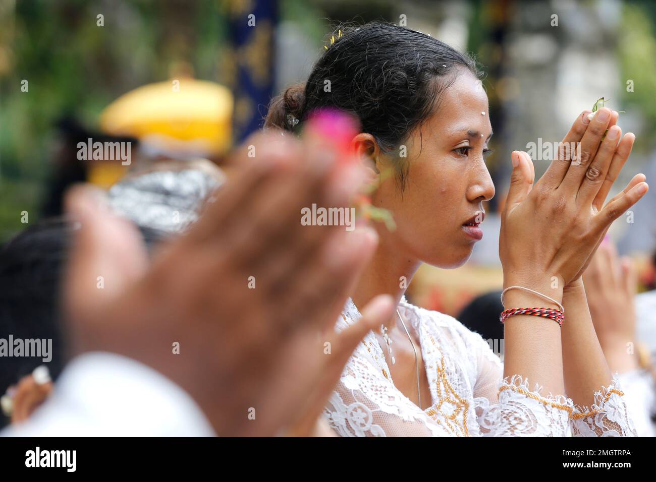 A Balinese woman prays to celebrate the Kuningan festival at a Hindu ...