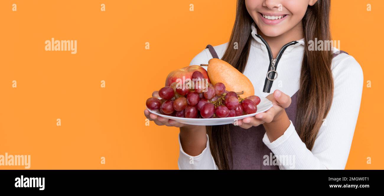 smiling child hold fruit plate on yellow background Stock Photo - Alamy