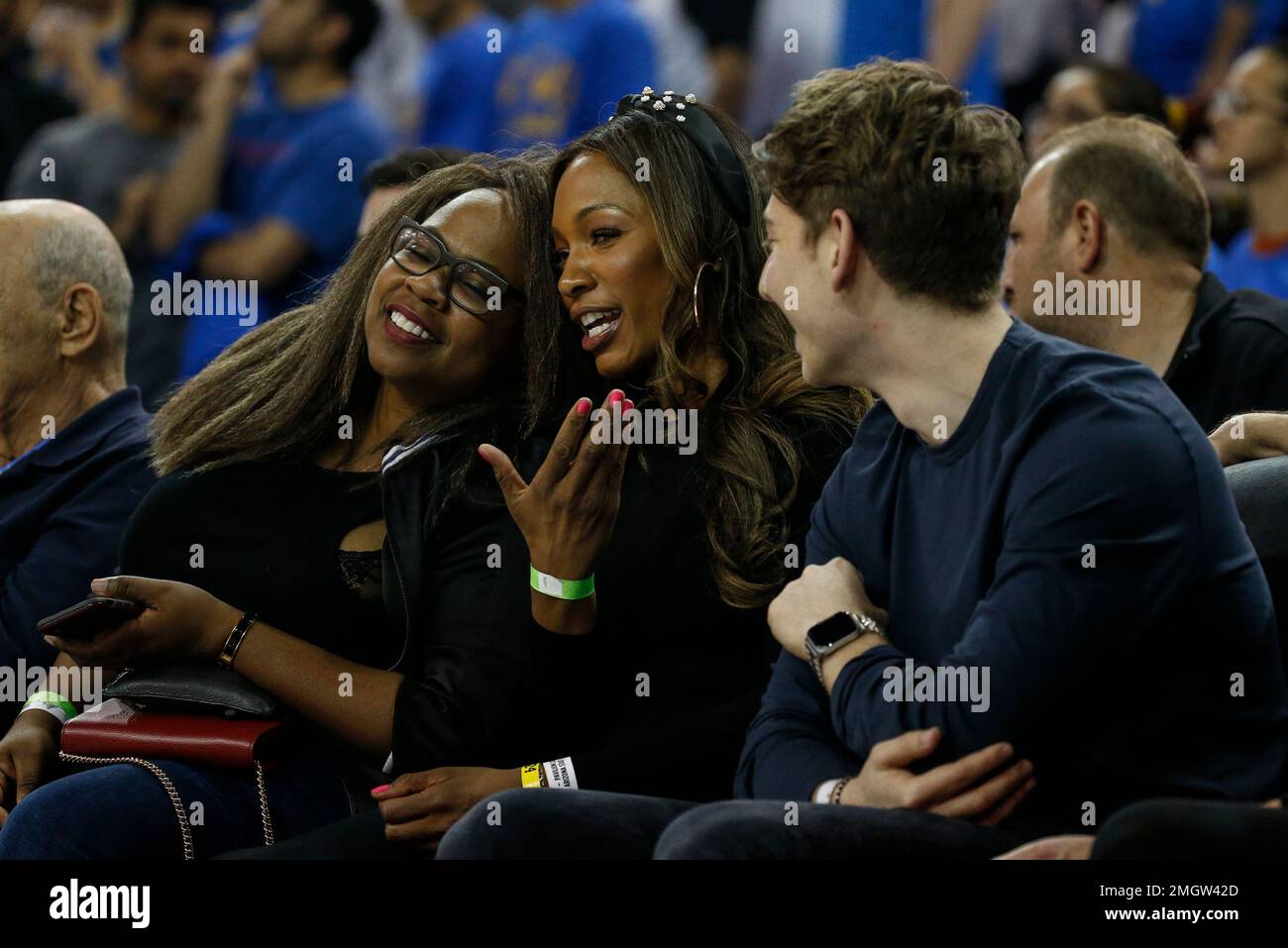 Cari Champion, center, attends an NCAA college basketball game between ...