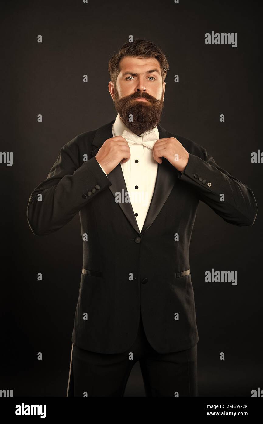 elegant butler in tuxedo on black background, bow tie Stock Photo - Alamy
