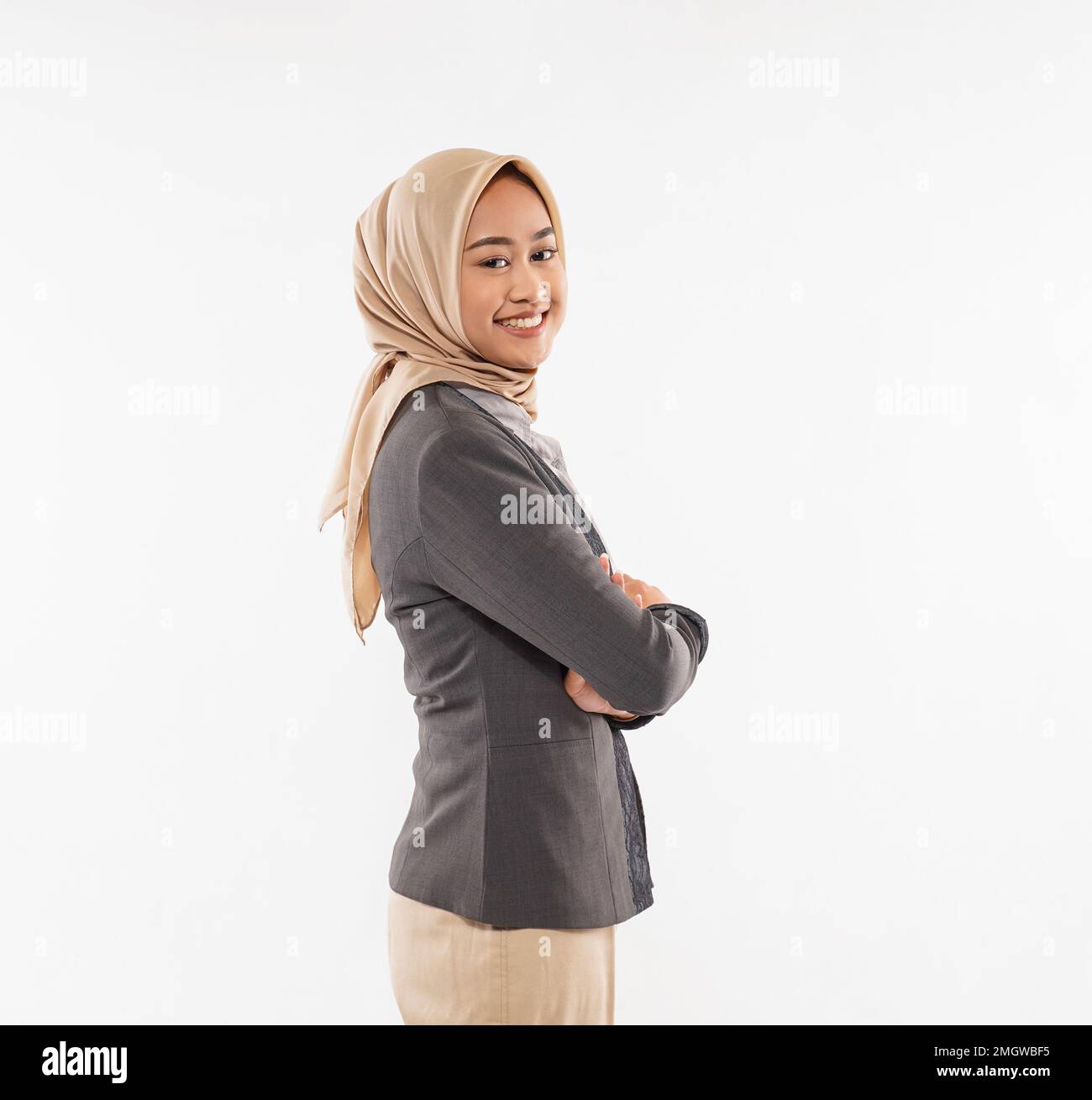 a beautiful woman with hijab standing facing left with hand crossed ...