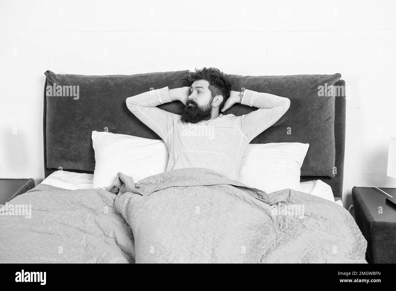 Drowsy guy being in bed awake after sleep, morning Stock Photo - Alamy