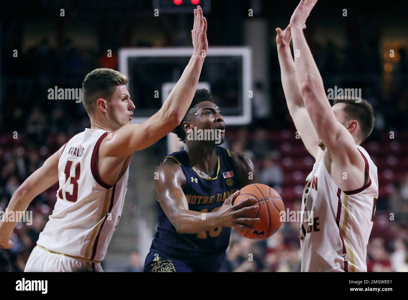 Notre Dame guard TJ Gibbs, center, threads between Boston College ...