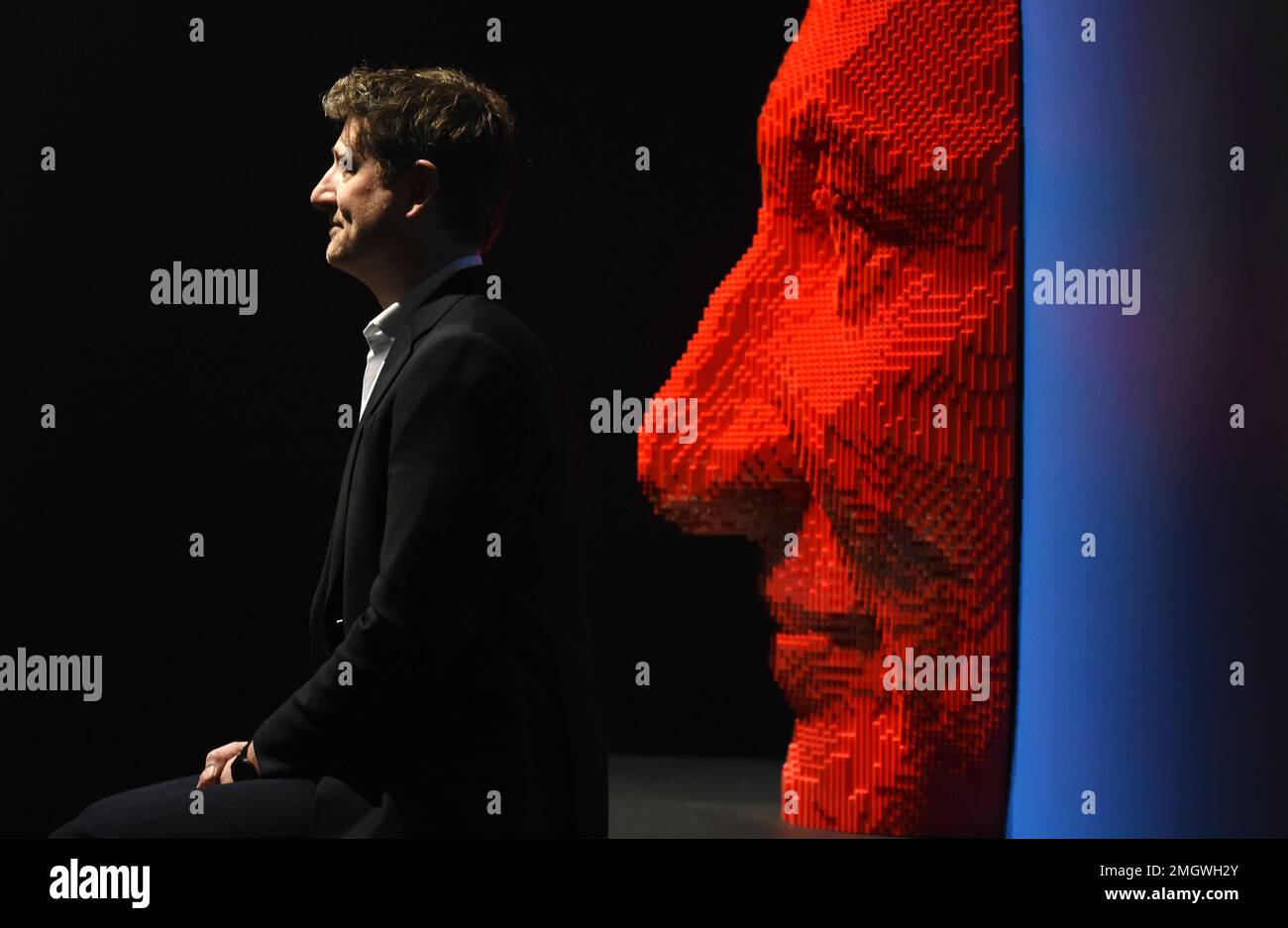Contemporary artist Nathan Sawaya sits next to his LEGO self-portrait ...