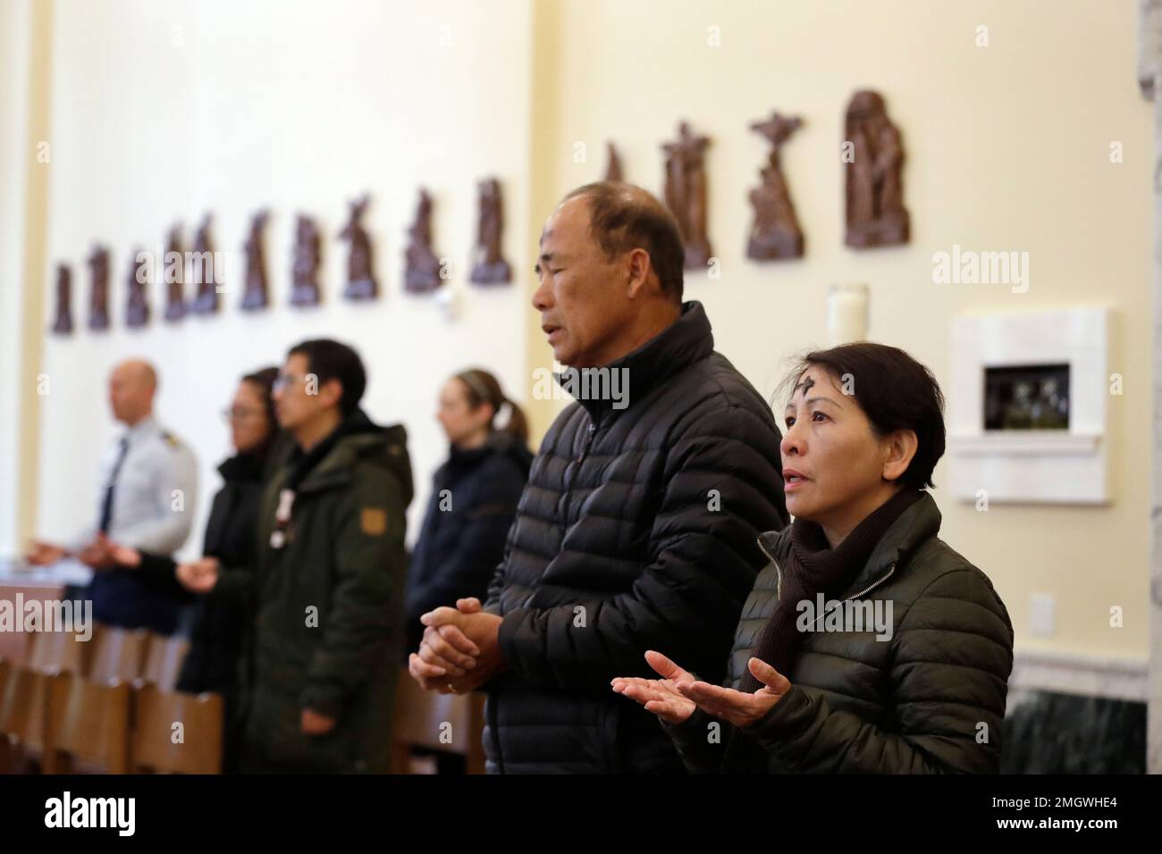 Mina Nguyen, right, and her husband Huu Tran pray with others after ...