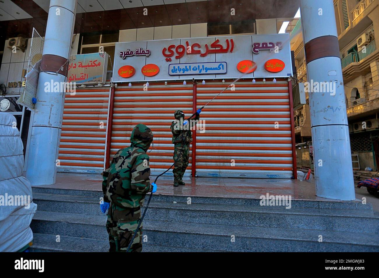 Iraqi health officials and Civil Defense staff wearing protective suits ...