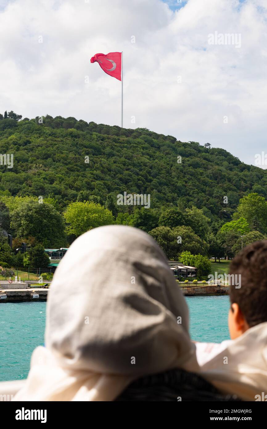 Giant Turkish flag on hillside seen by tourists on Bosphorus river ...