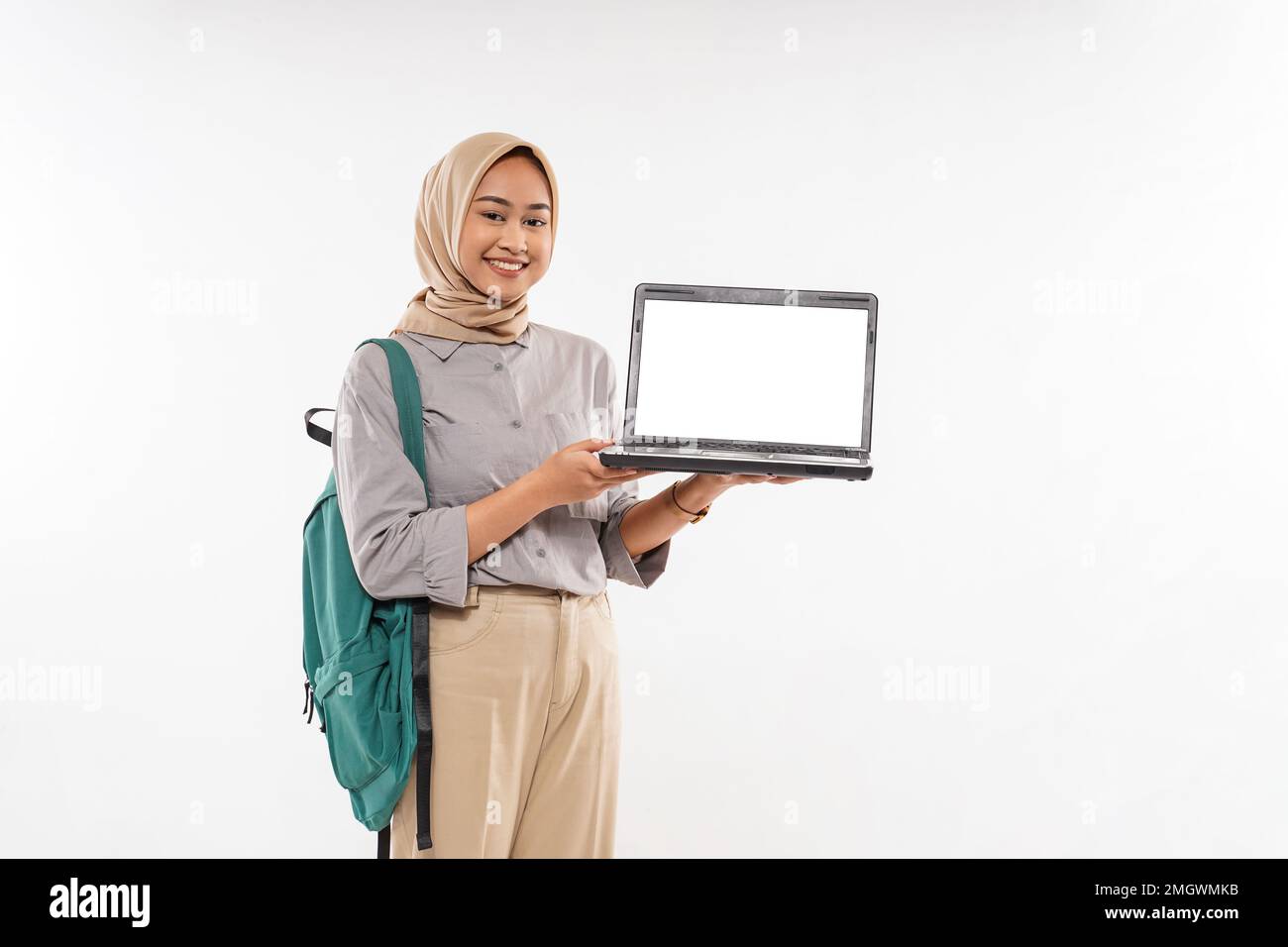 a beautiful student with hijab standing and showing the opened laptop ...