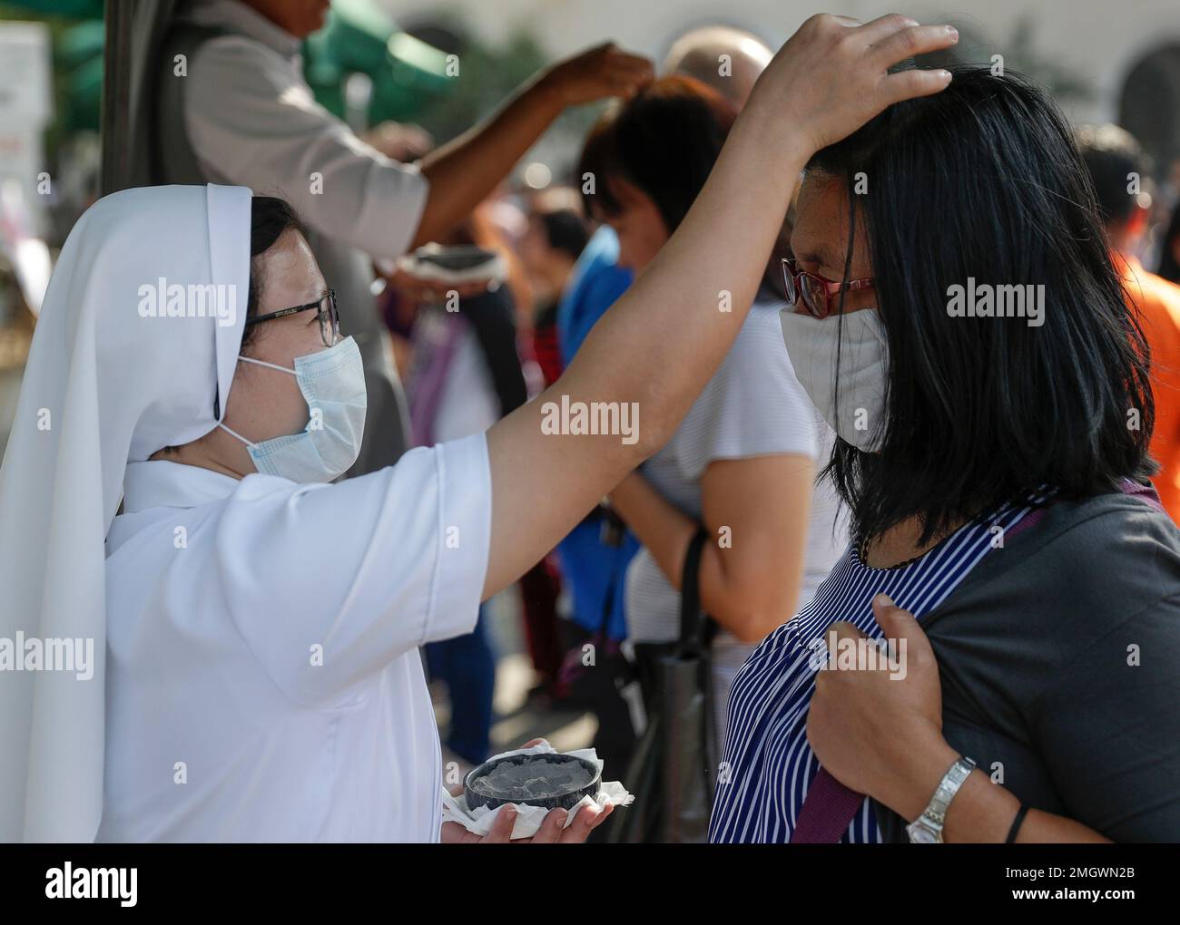 A Catholic nun sprinkles ash on the head of a devotee as they wore ...