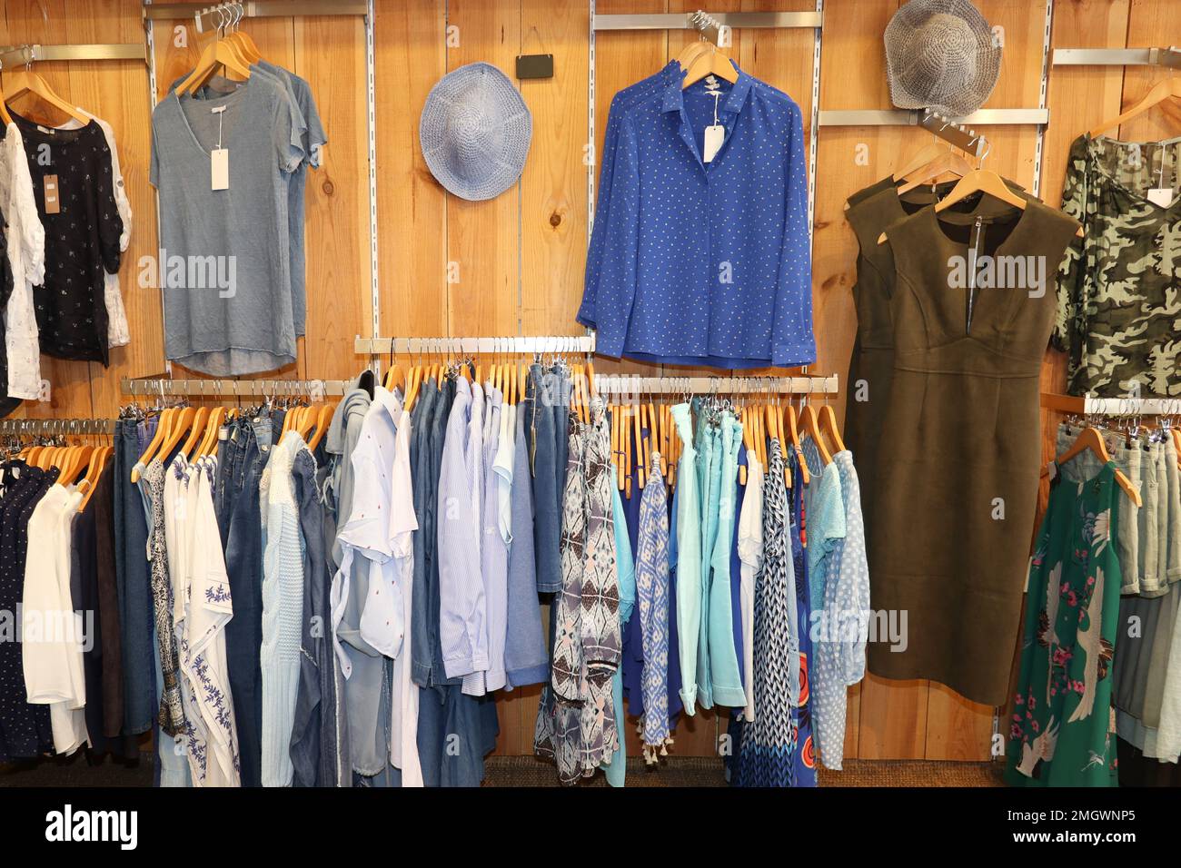 Variety of clothes hanging on rack in boutique interior view of women ...