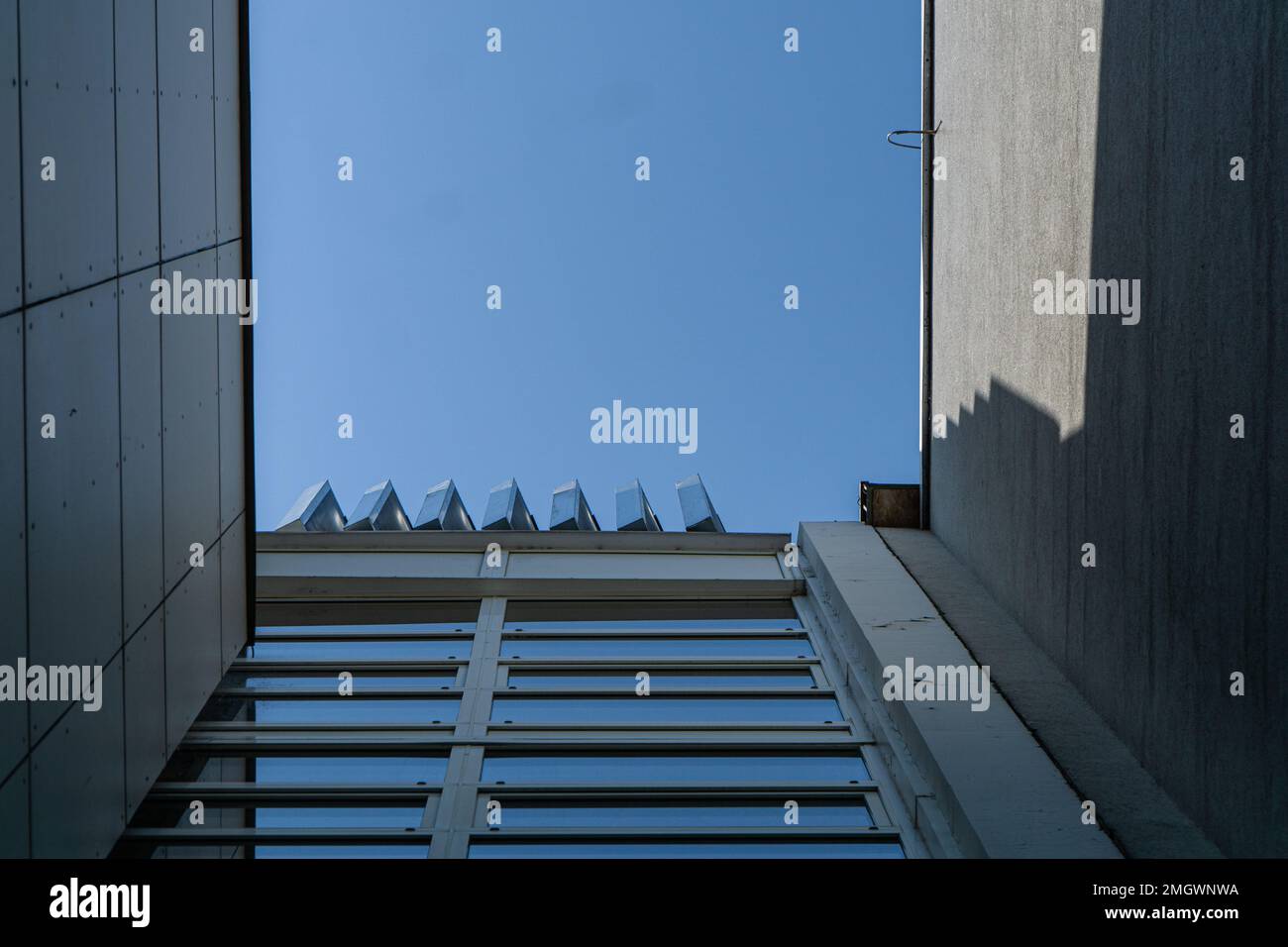 office building with windows photographed from below under blue sky ...