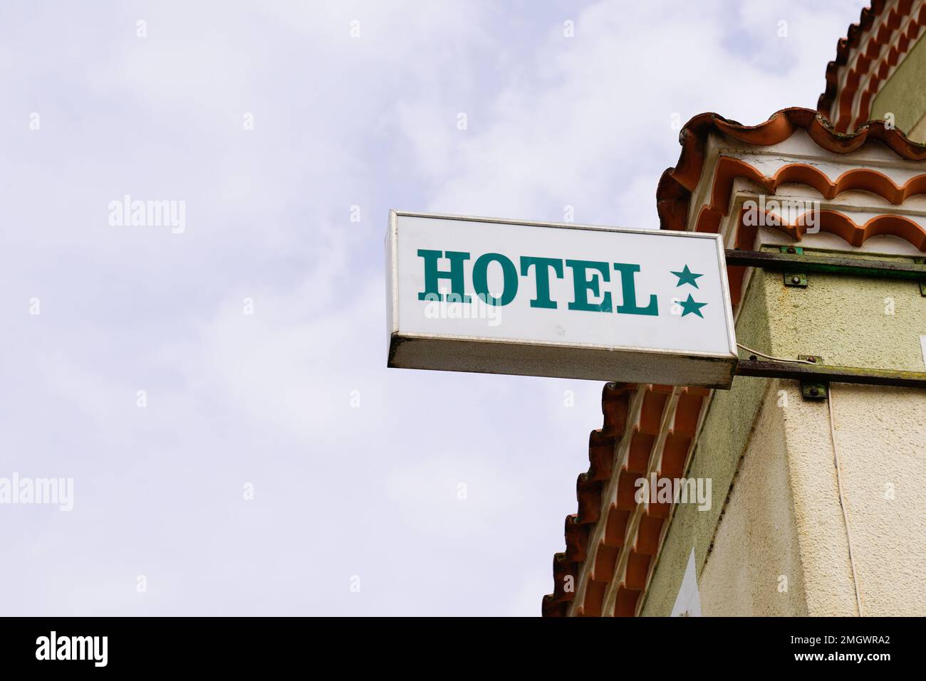 Hotel light sign green text and two stars on Building in tourist city ...