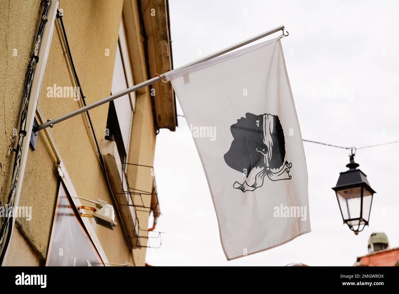 Corsican flag hanging in the street has a balcony in an old town of the ...