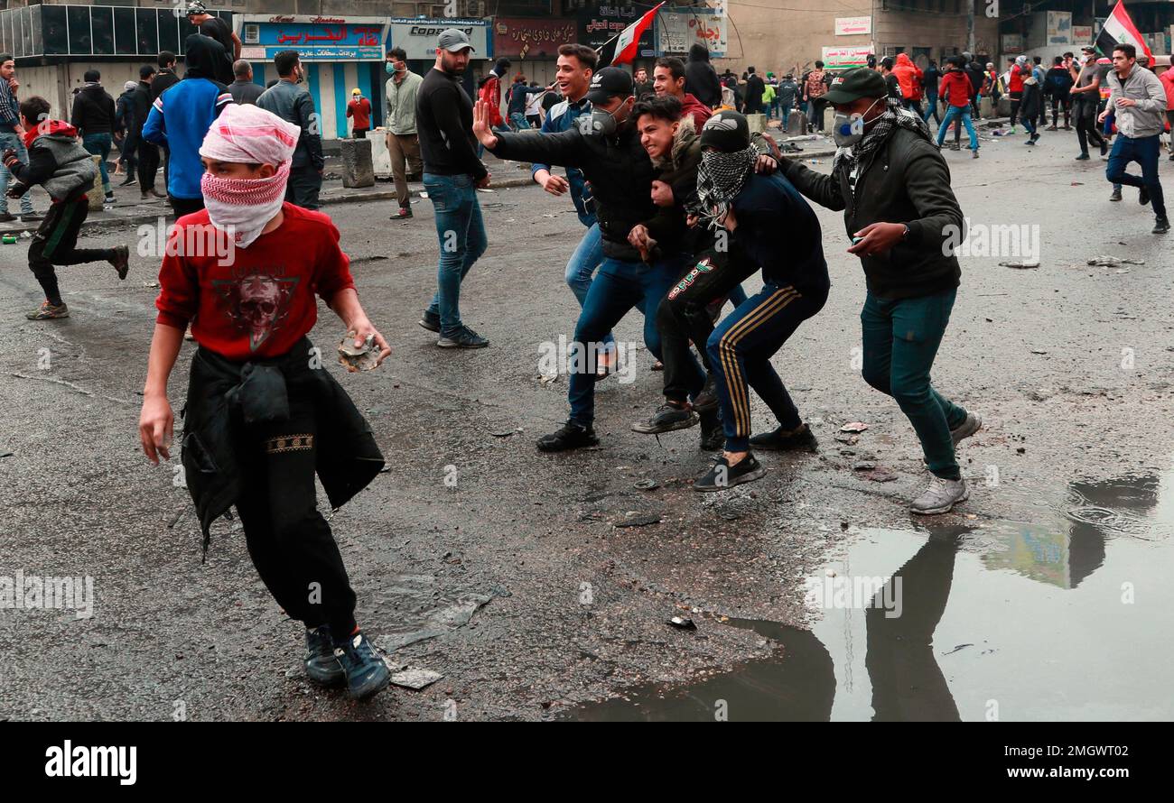 Anti-government protesters run to cover during clashes with security ...