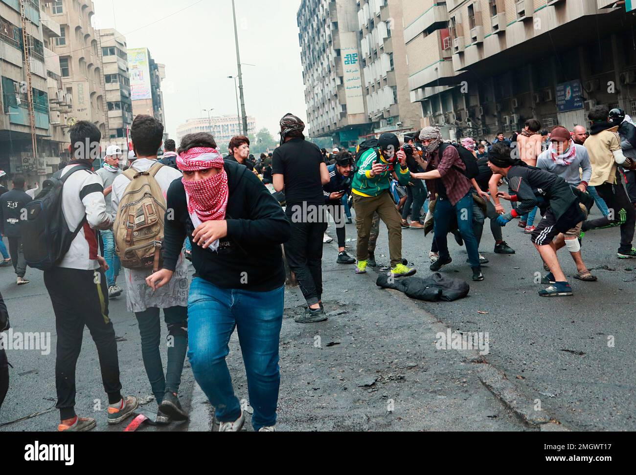 Anti-government protesters run to cover during clashes with security ...