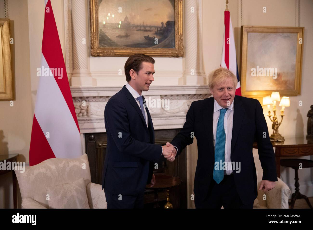 British Prime Minister Boris Johnson, right, performs a posed handshake ...