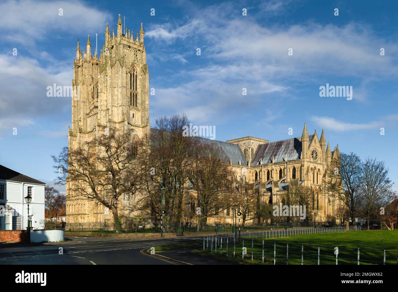 The ancient minster (church) on a bright sunlit day flanked by trees ...