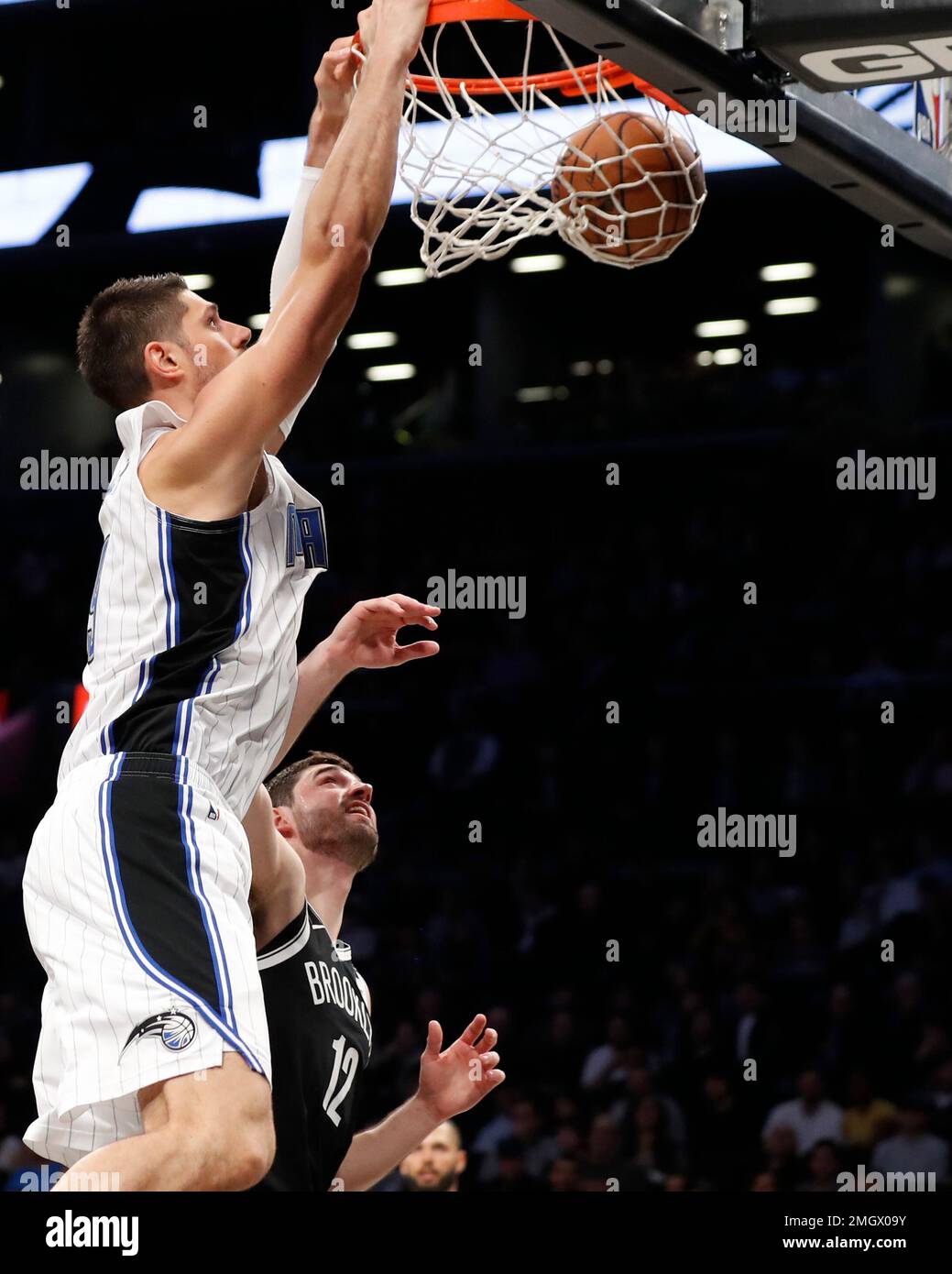 Orlando Magic center Nikola Vucevic, top, dunks over Brooklyn Nets ...