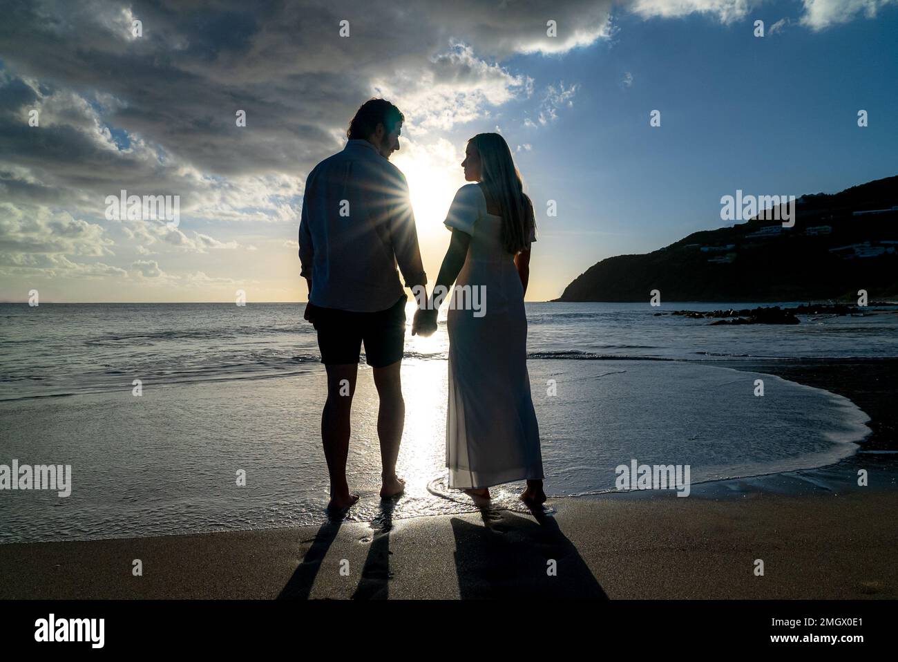 silhouette of young engaged couple holding hands in love during the ...