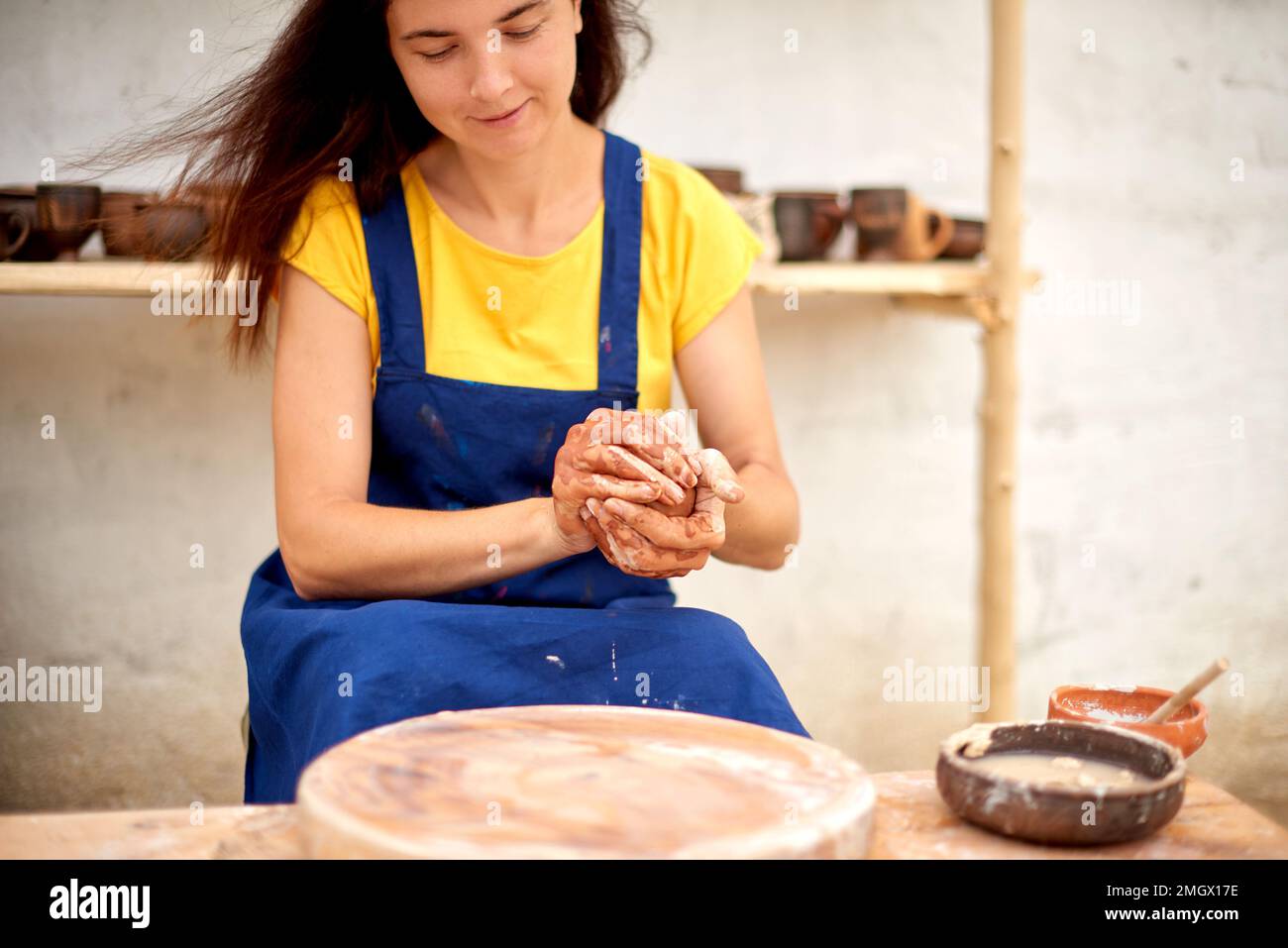 making sphere shape from clay for manufacture of pottery product. woman ...