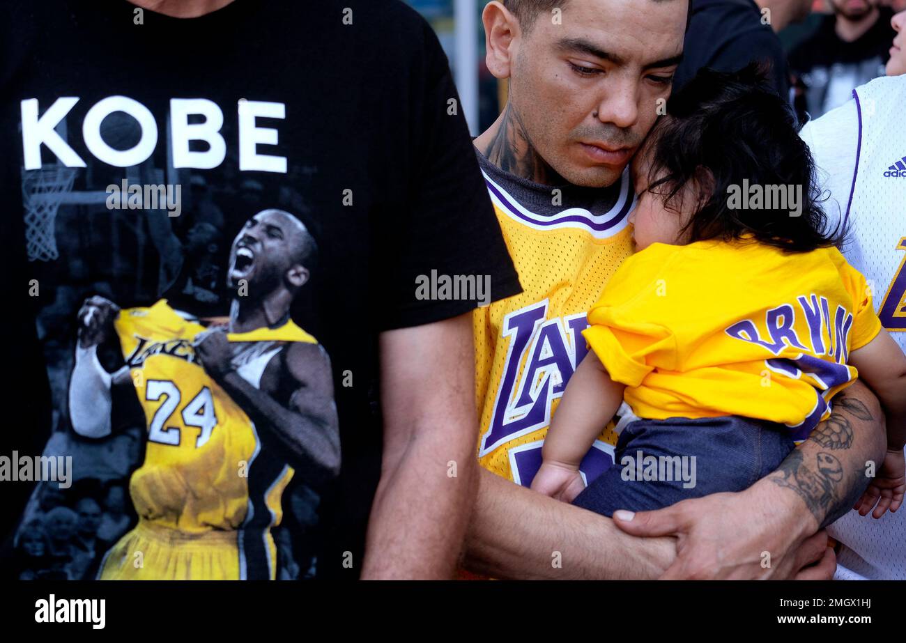 Erik Dominguez holds his 11-month-old daughter Isabella while watching ...