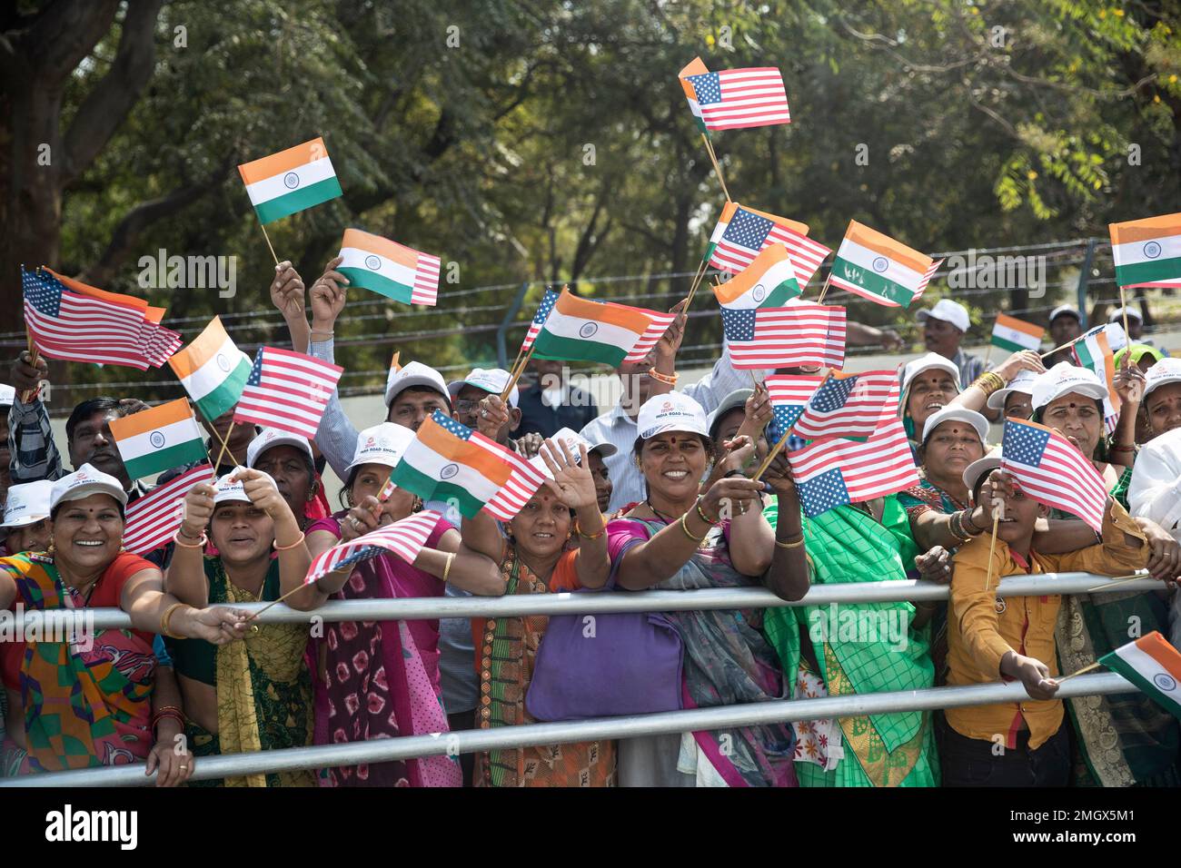 People line the street and wave flags as the motorcade for President ...
