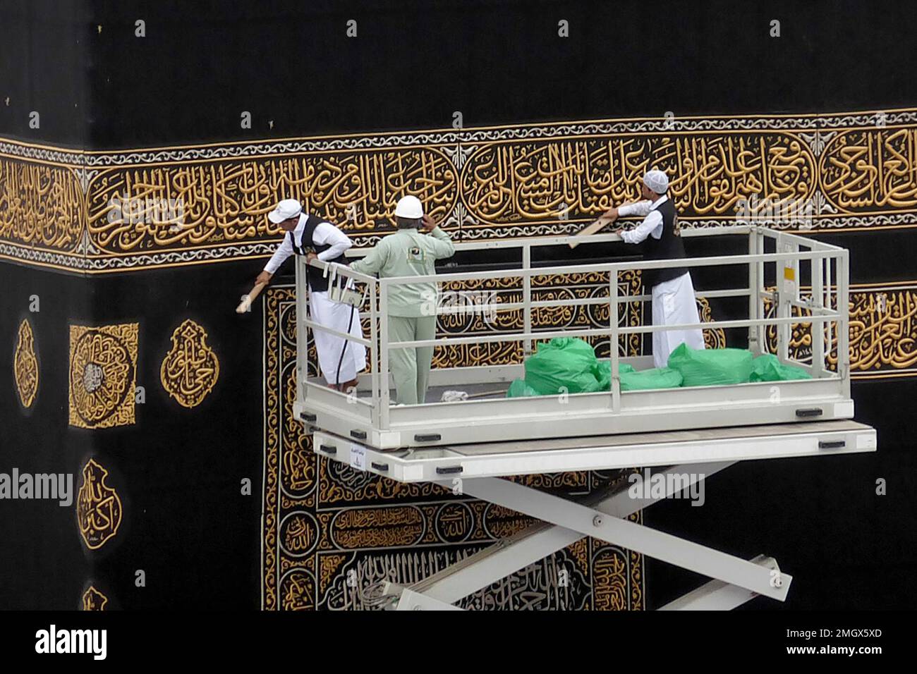 Workers clean the Kiswah, the cloth that covers the Kaaba, the cubic ...