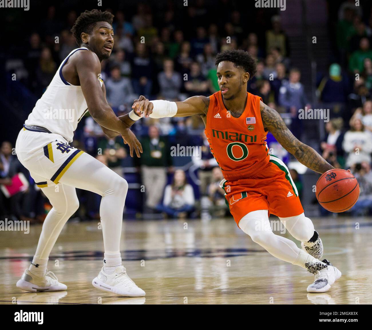 Miami's Chris Lykes (0) drives around Notre Dame's Temple 'T.J.' Gibbs ...