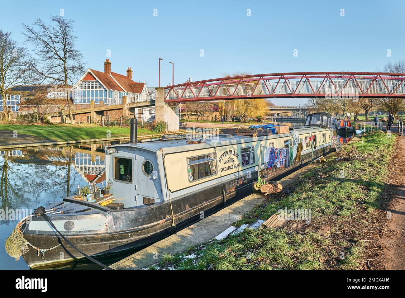 A canal longboat moored by the Cutter Ferry pedestrian bridge over the ...