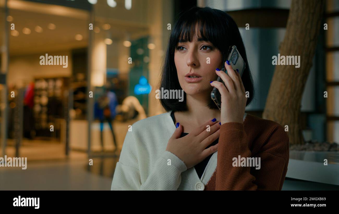 Worried upset shocked woman indoors answer call talking phone ...