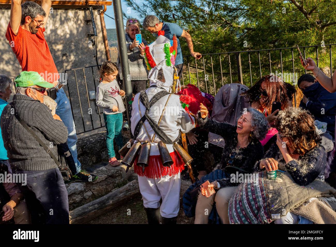 A masked reveller dressed as Botarga, center, throws fluff to ...