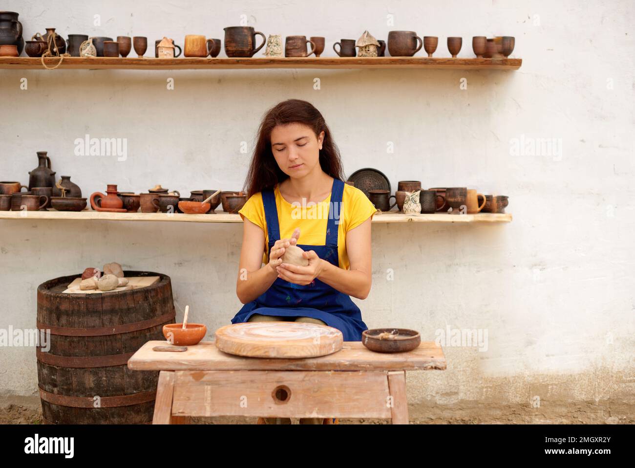 professional potter with clay lump in hands. woman work on pottery ...