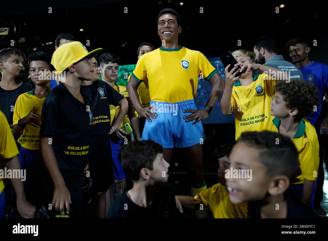 Children stand next to the statue of legendary Brazilian player Pele at ...