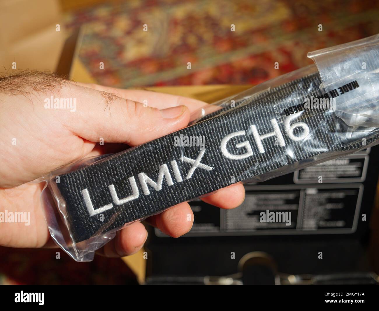 Paris, France - Dec 2, 2022: Male hand holding shoulder strap for the new Panasonic Lumix GH6 ...