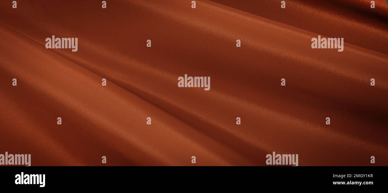 The texture of a smooth elegant fabric of silk, satin brown with folds ...