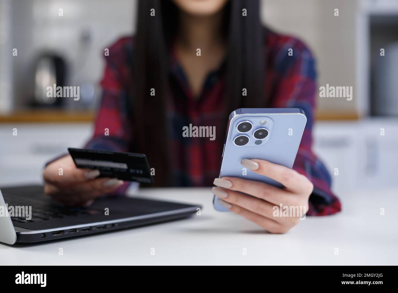 Girl pays with credit card and smartphone app. Young female shopping ...