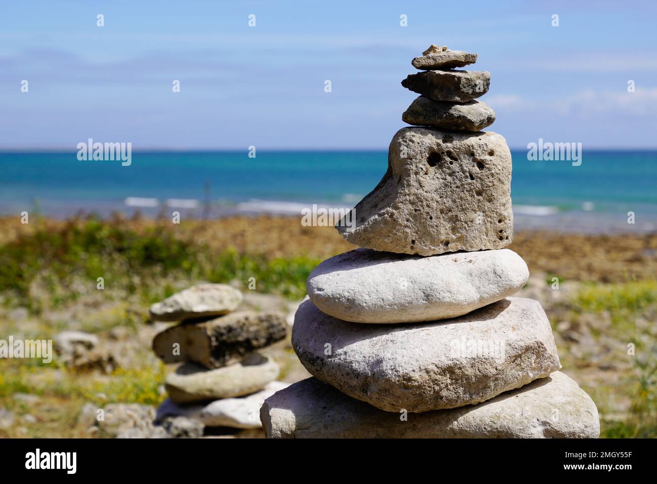 Pile of some pebbles zen balanced stones stack on sea water coast beach ...