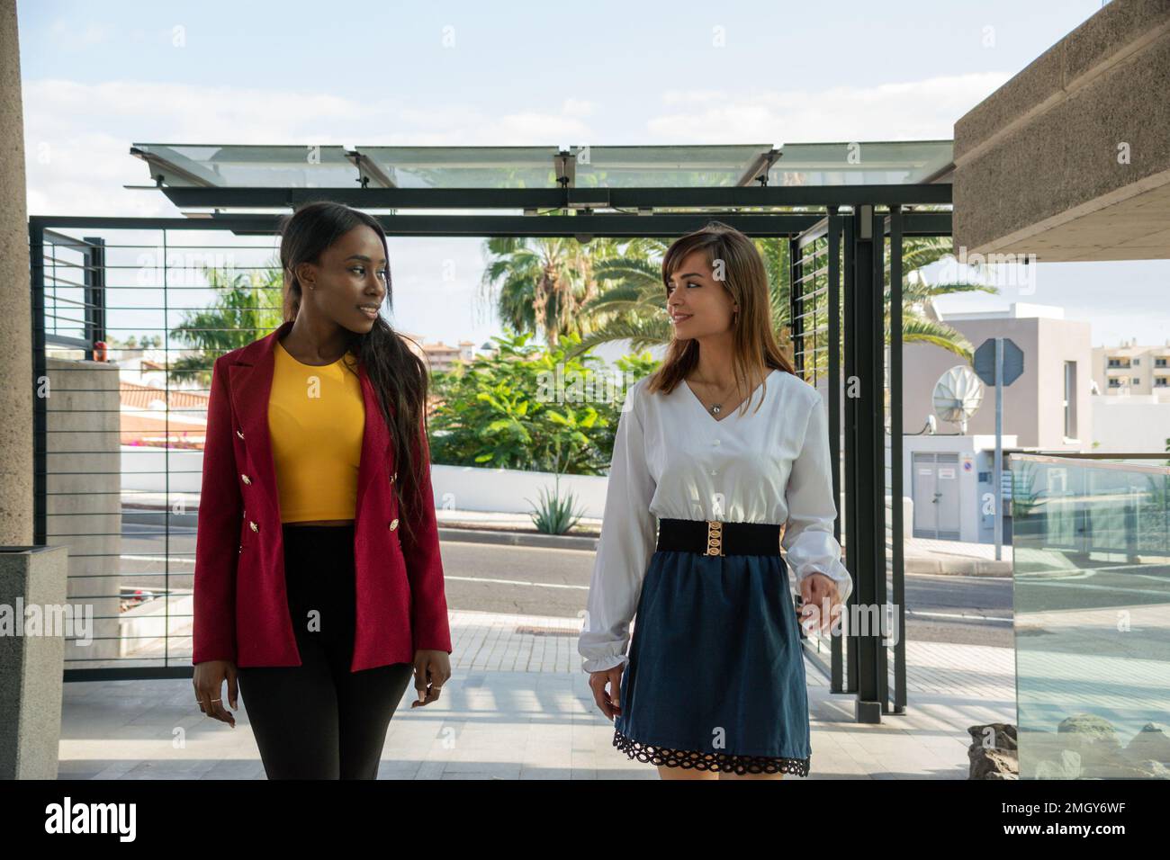 Two young businesswomen look at each other as they enter their ...