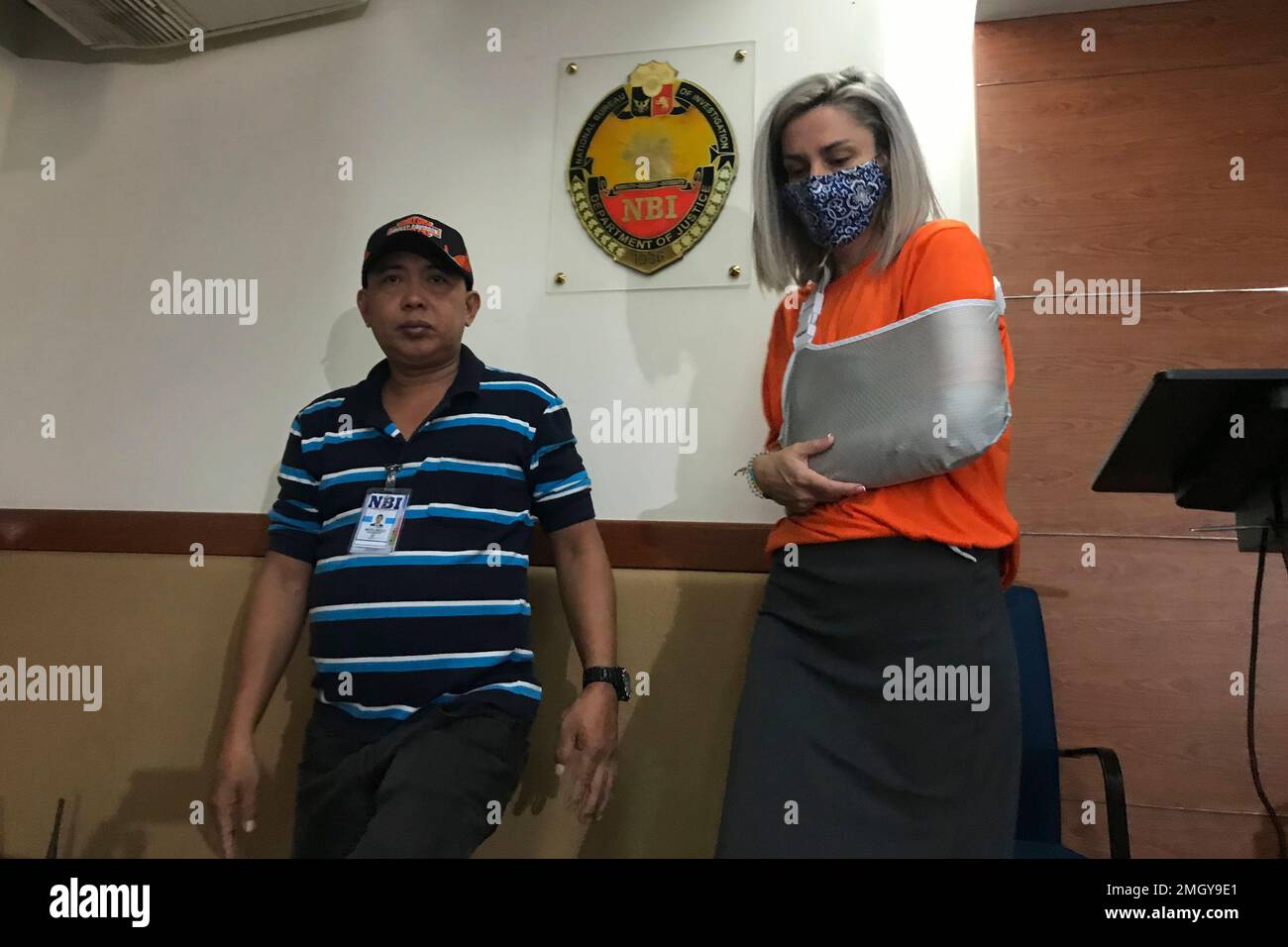 Jennifer Talbot wears a face mask as she is escorted by an agent of the ...