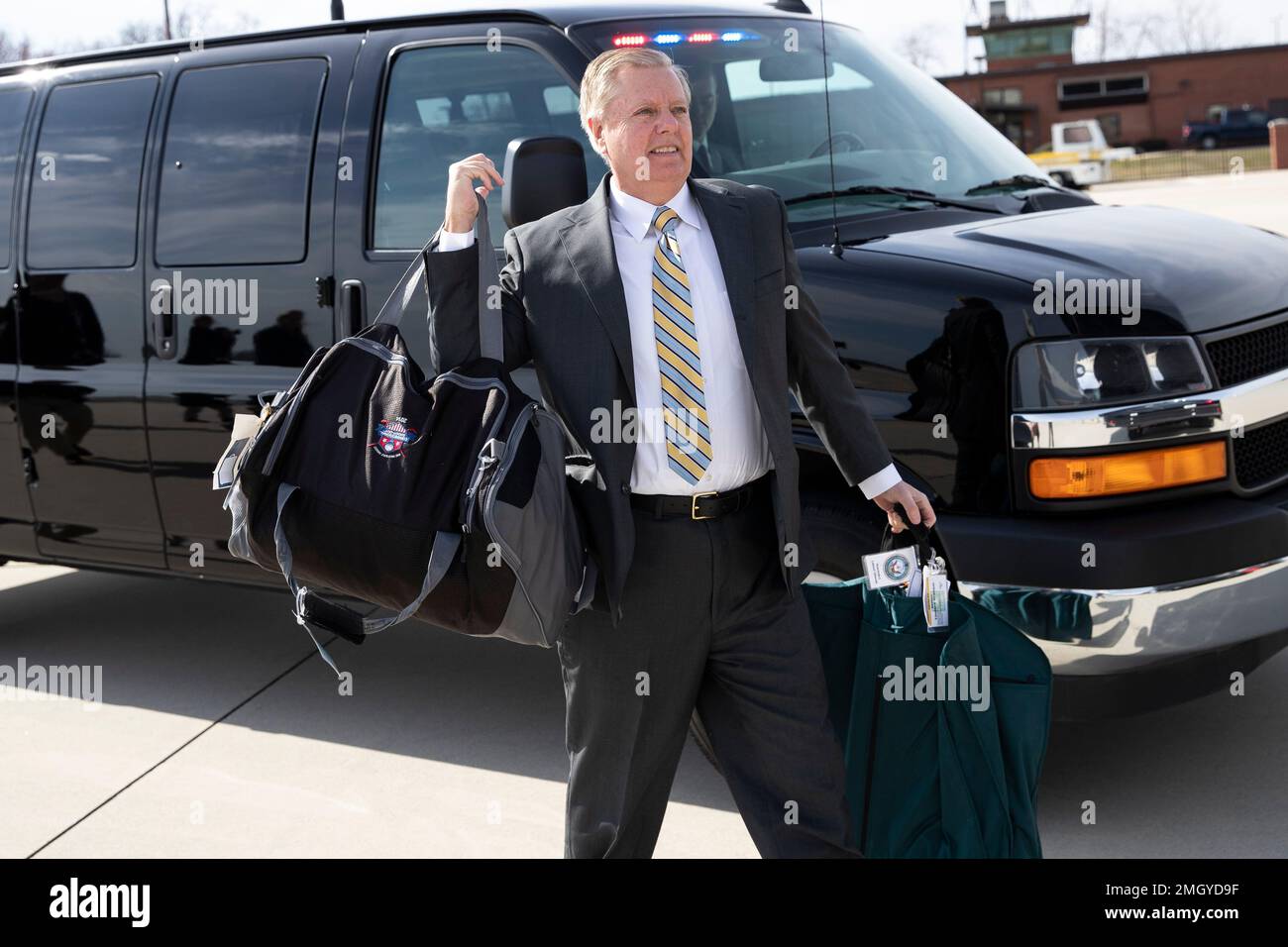 Sen. Lindsey Graham, R-S.C., grabs his bags to board Air Force One with ...